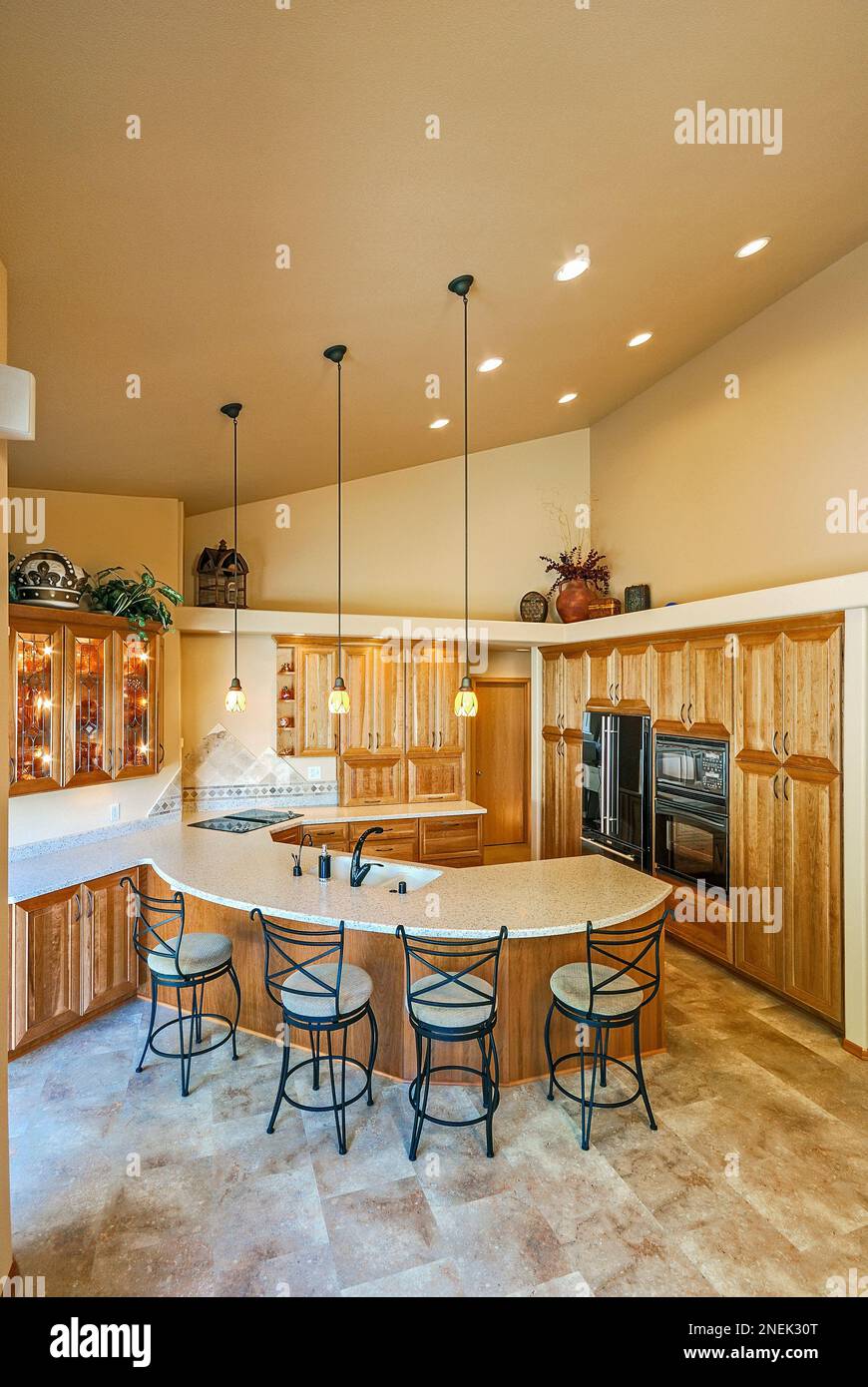 Views of a semi-circular countertop with 4 chairs and wood cabinets in ...