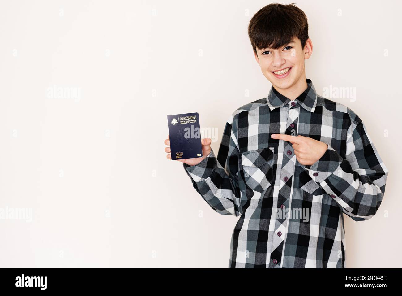 Young teenager boy holding Lebanon passport looking positive and happy ...
