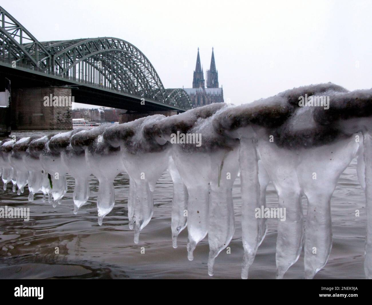 Icicle hang from chain links over the river Rhine with Cologne ...