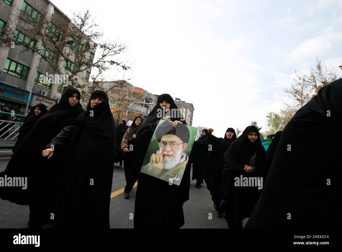 A female Iranian demonstrator holds a poster of the supreme leader ...