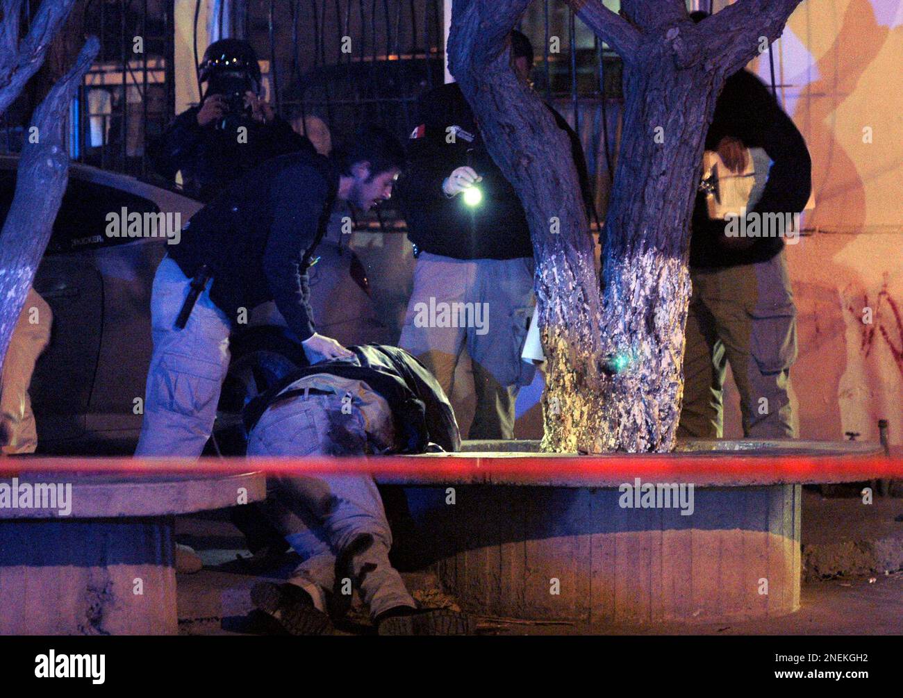 Mexican forensic workers examine a crime scene after a man was killed ...