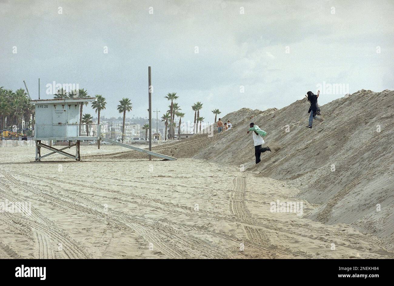 Beachgoers walk down a 15-foot high berm near Venice beach in Los ...