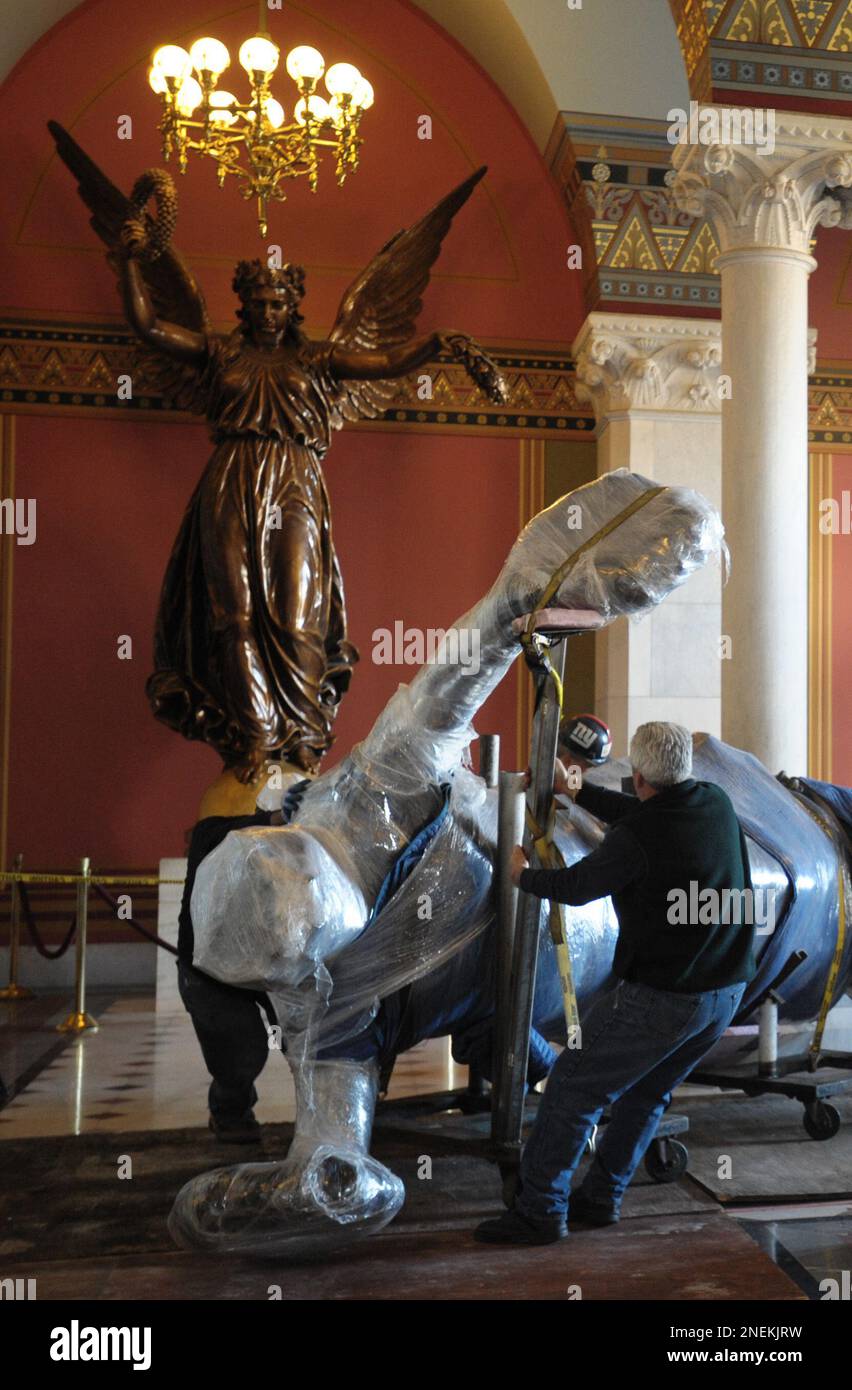 Workers pull an 18-foot-tall winged allegorical statue known as the ...
