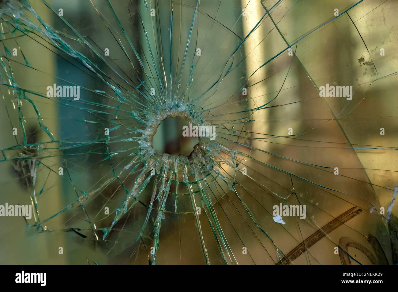 A hole in the window glass with a bullet during a military shooting ...