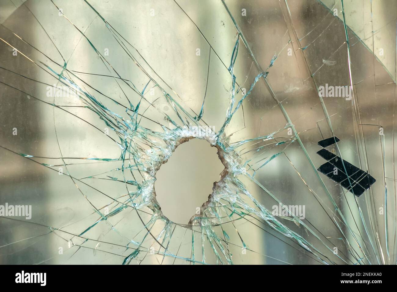A hole in the window glass with a bullet during a military shooting ...