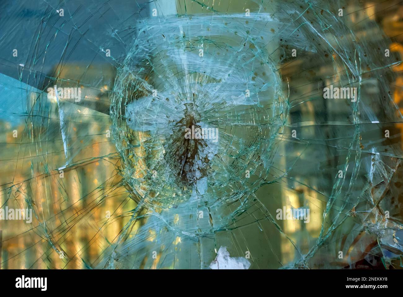 A hole in the window glass with a bullet during a military shooting ...