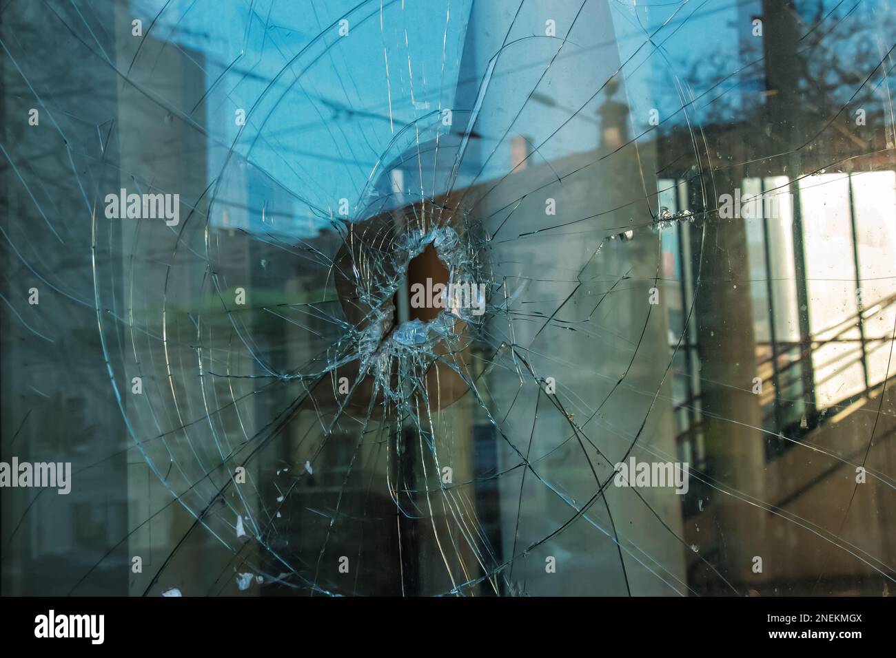 A hole in the window glass with a bullet during a military shooting ...