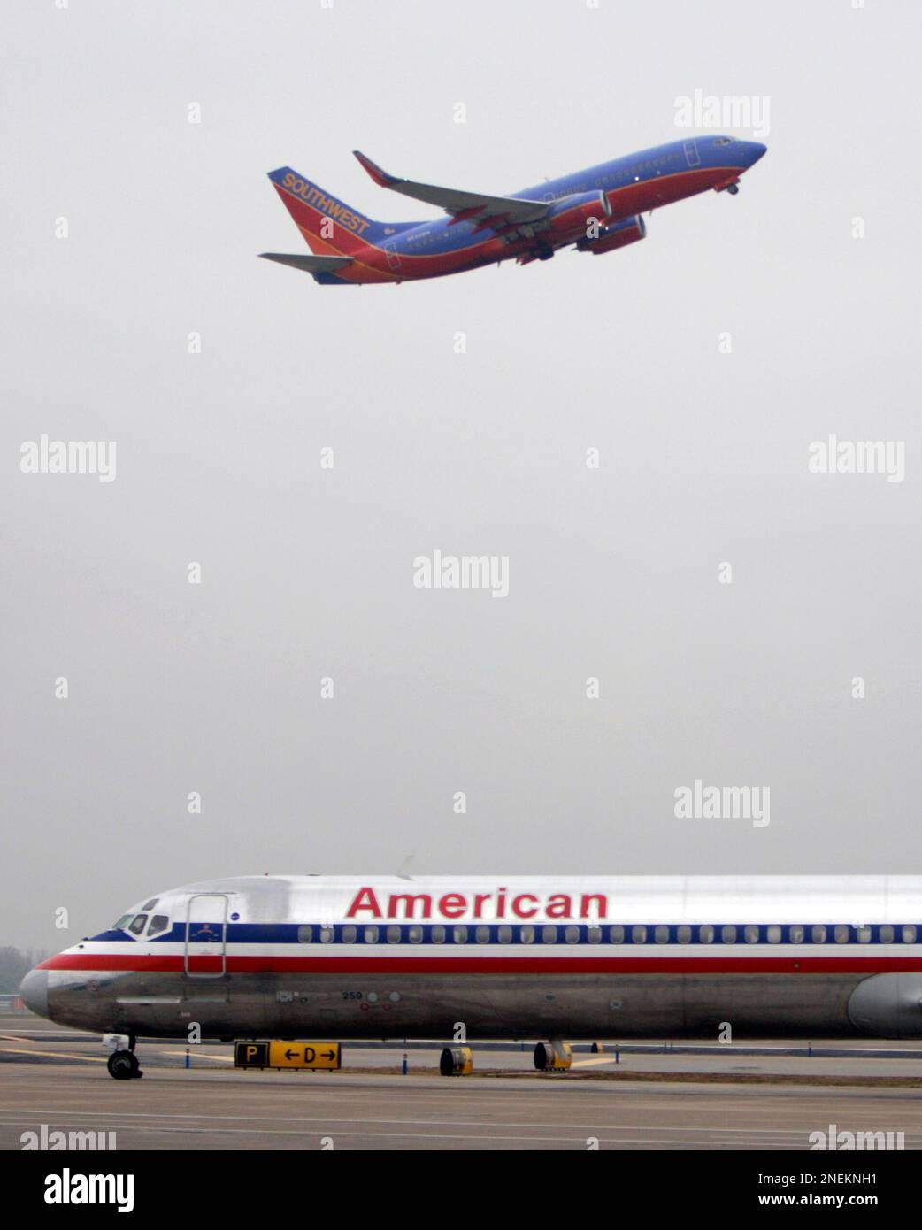 A Southwest Airlines jet takes off as an American Airlines jet taxies ...