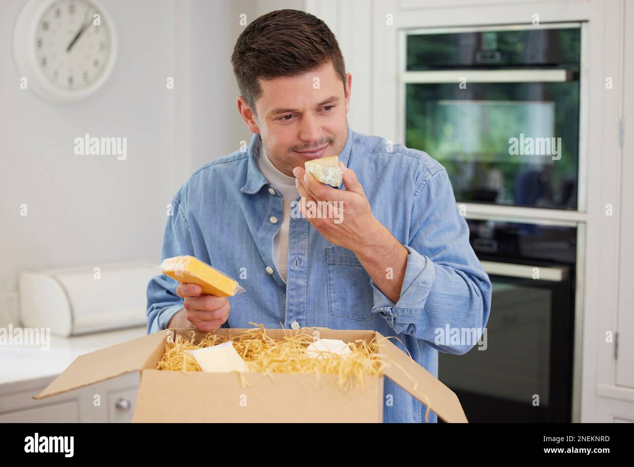 Man Unpacking Online Luxury Cheeses Delivered To Home Stock Photo - Alamy