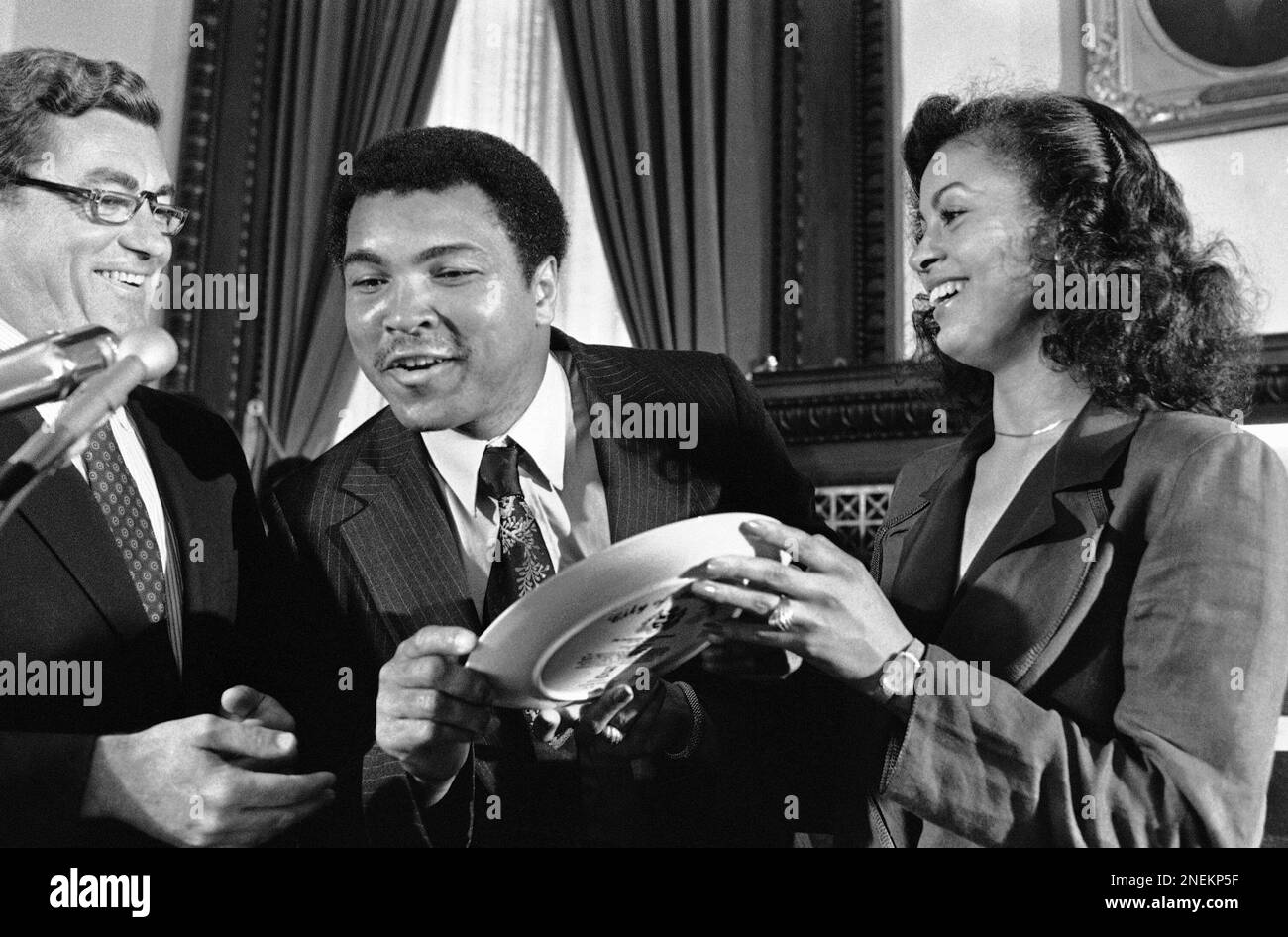 Former heavyweight boxing champ Muhammad Ali hams it up after his wife ...