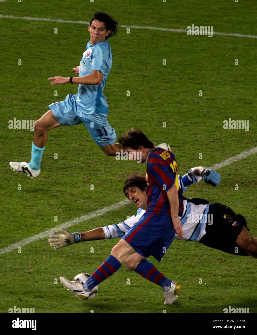 Barcelona's Lionel Messi, bottom, scores past Atlante's goalkeeper ...