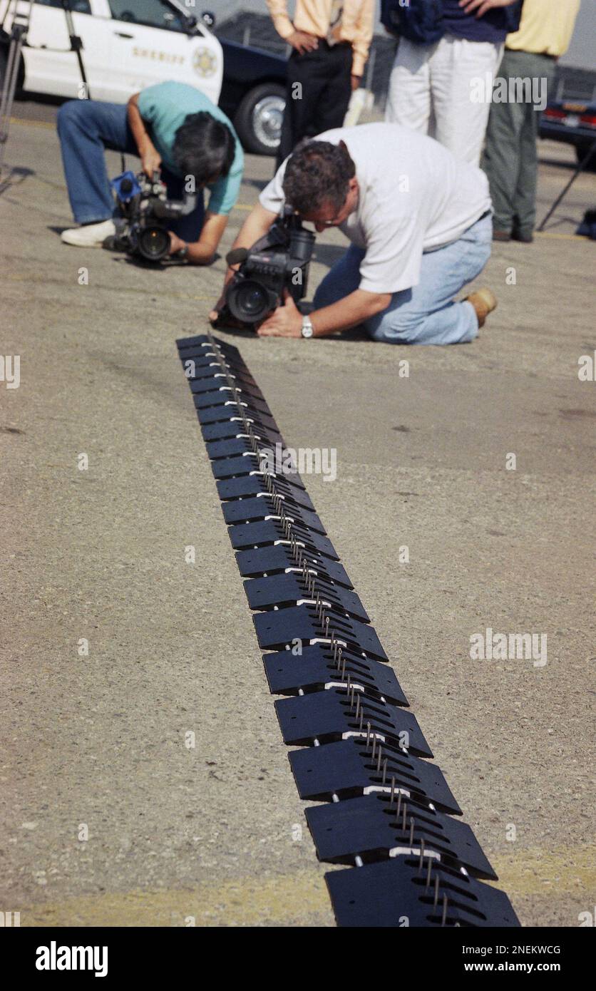 Television cameramen photograph a remote-controlled strip of tire ...