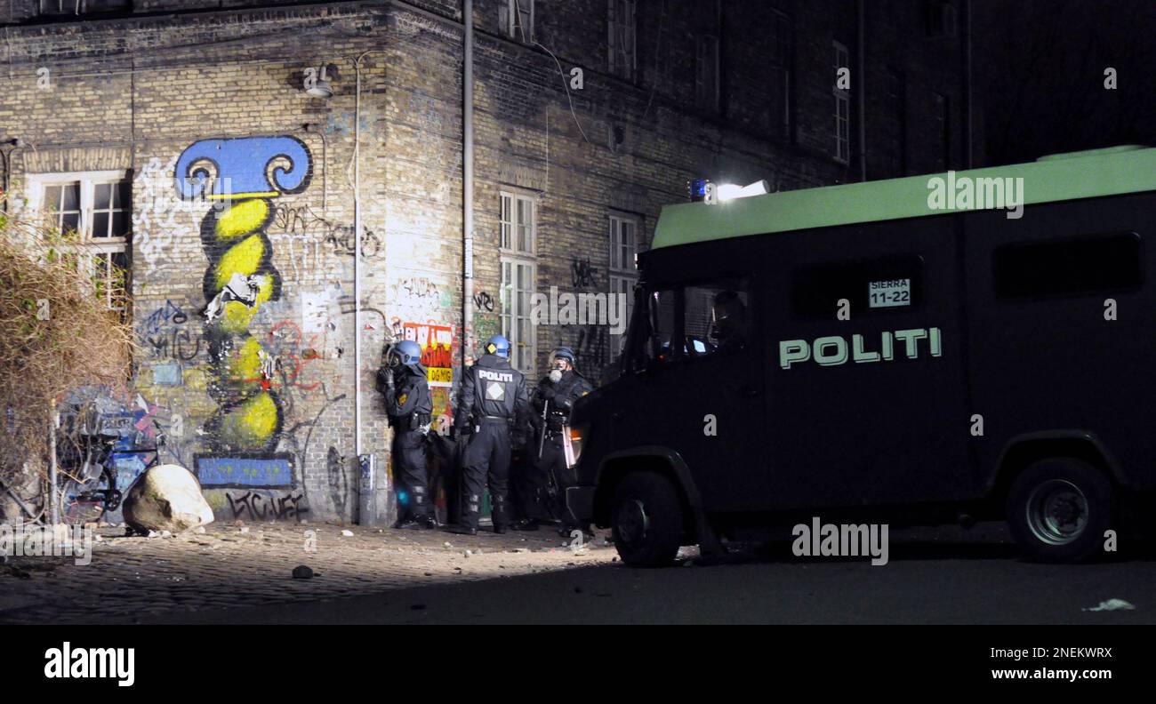 Police officers stand behind a building in the downtown Copenhagen ...