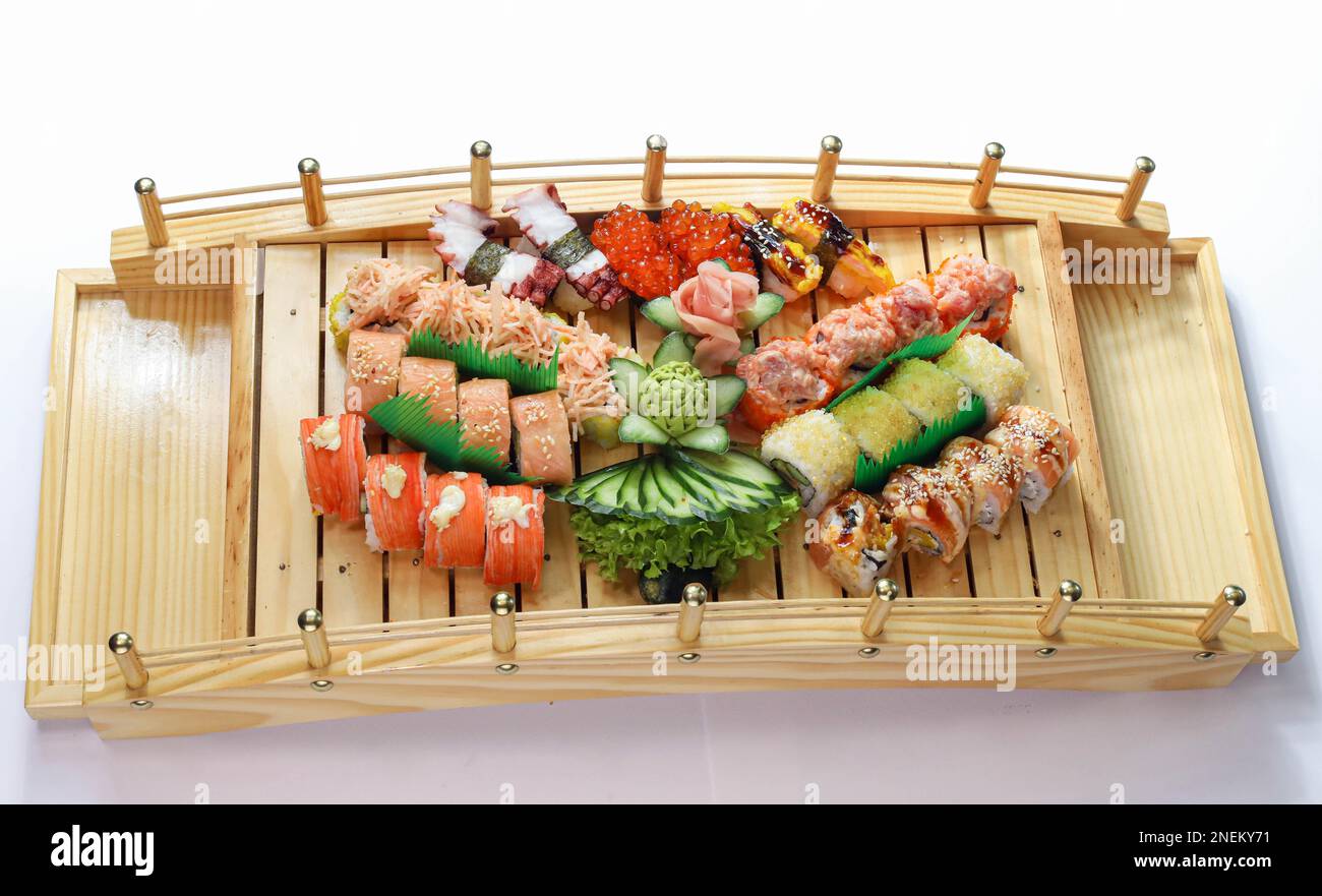 A closeup of some types of sushi roll set on a boat with white ...