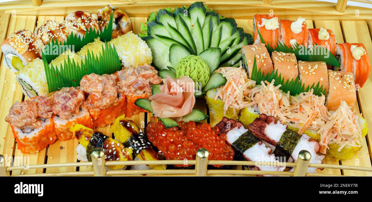 A closeup of some types of sushi roll set on a boat with white ...