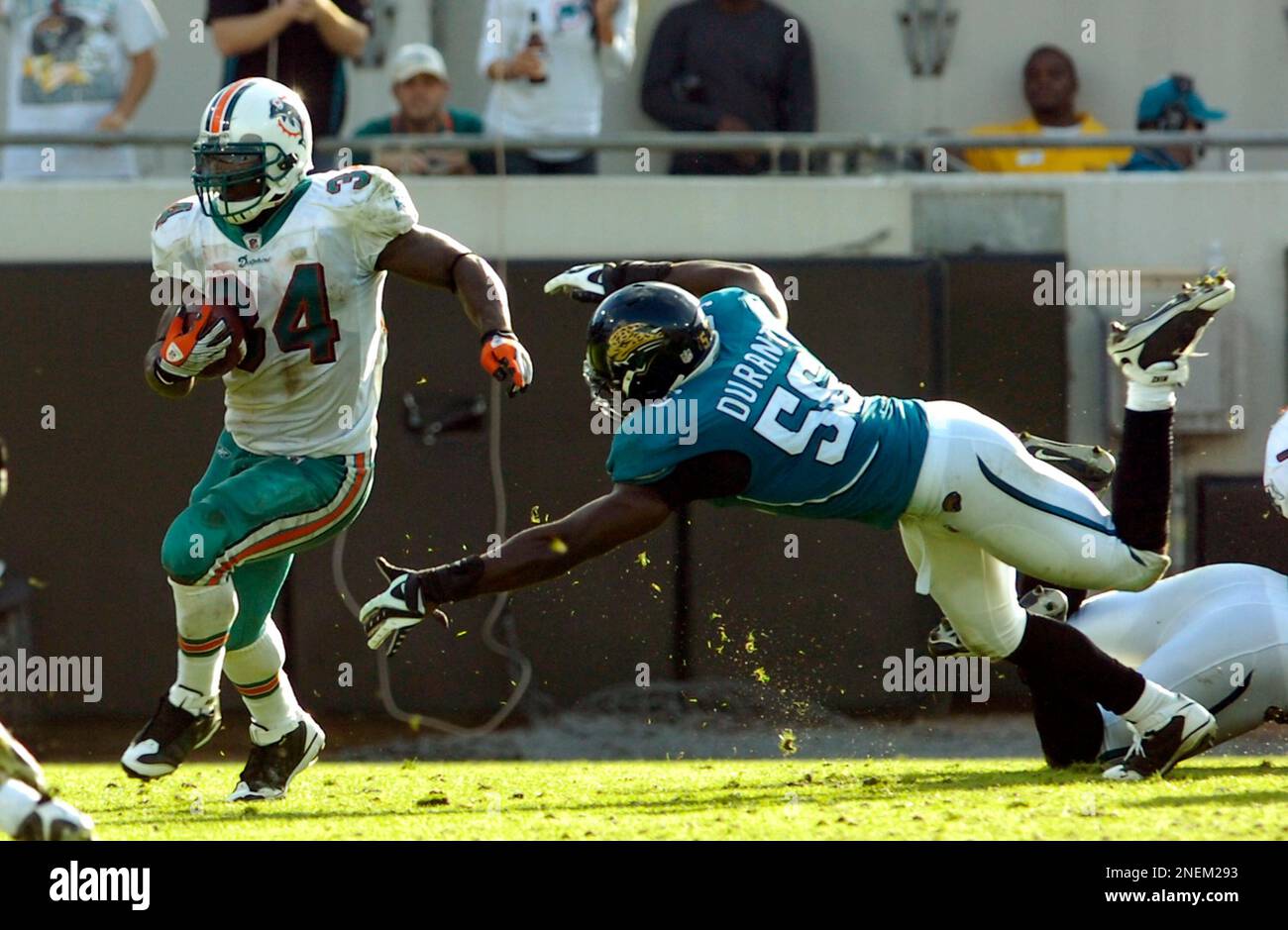 Miami Dolphins running back Ricky Williams, left, eludes a tackle by ...