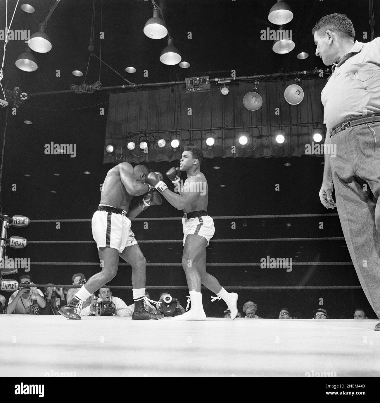 Handlers of Muhammad Ali (Cassius Clay) swarm over him in the ring ...