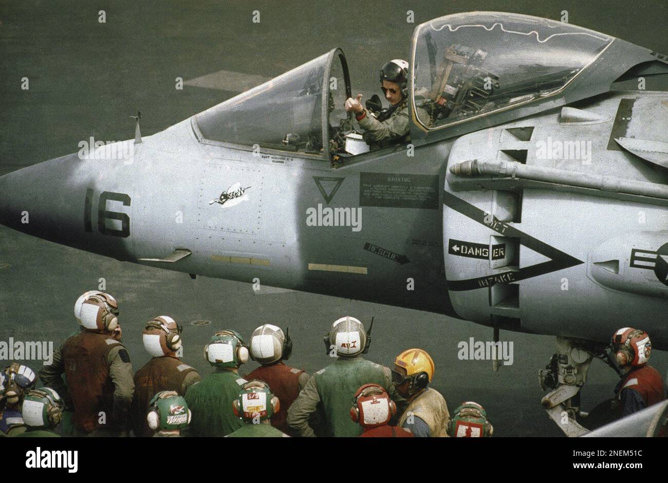 A U.S. Marine Harrier pilot gives the thumbs-up signal to a gathering ...
