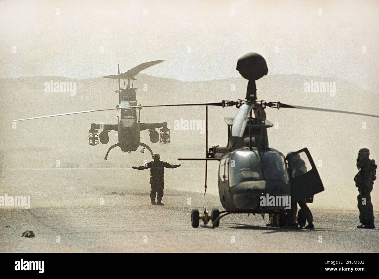 A US Army Cobra attack helicopter kicks up sand as it lands at the 82nd ...