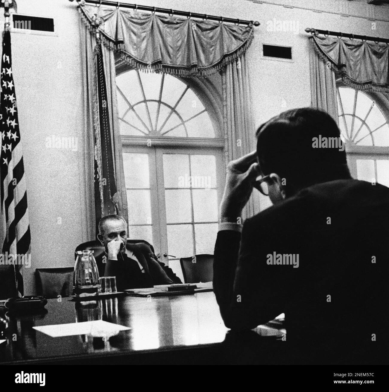 President Lyndon B. Johnson and his press secretary Bill Moyers confer ...