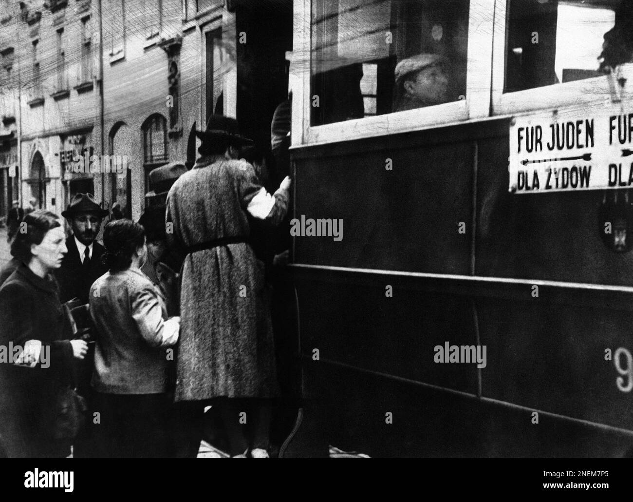A scene in the ghetto where Jews are seen wearing white armbands ...