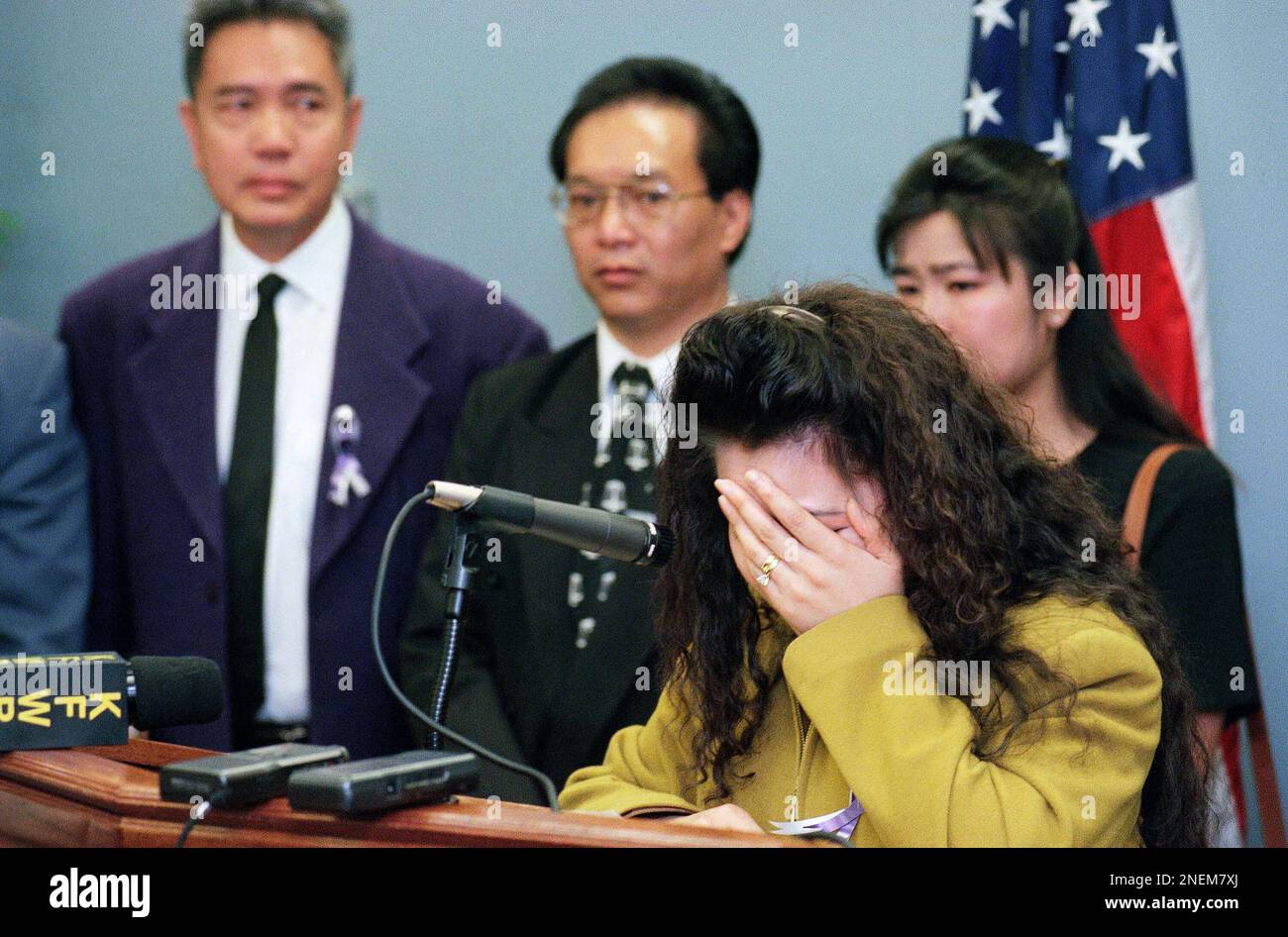 Sophia Ngor, niece of Haing Ngor, cover her face, and behind left to ...