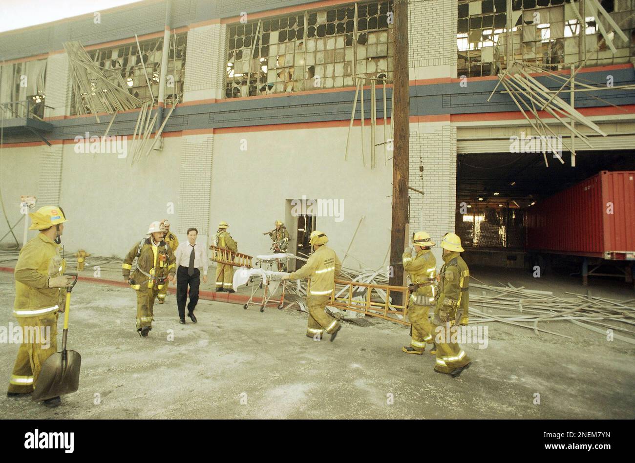 Los Angeles City Firefighters walk past shattered windows and debris ...