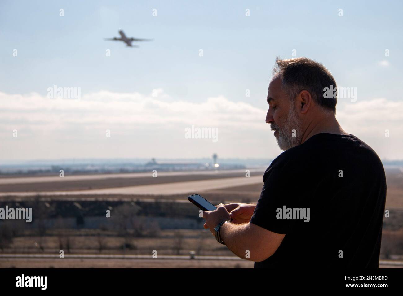 Slightly bald adult man dressed in black watching and pointing as ...