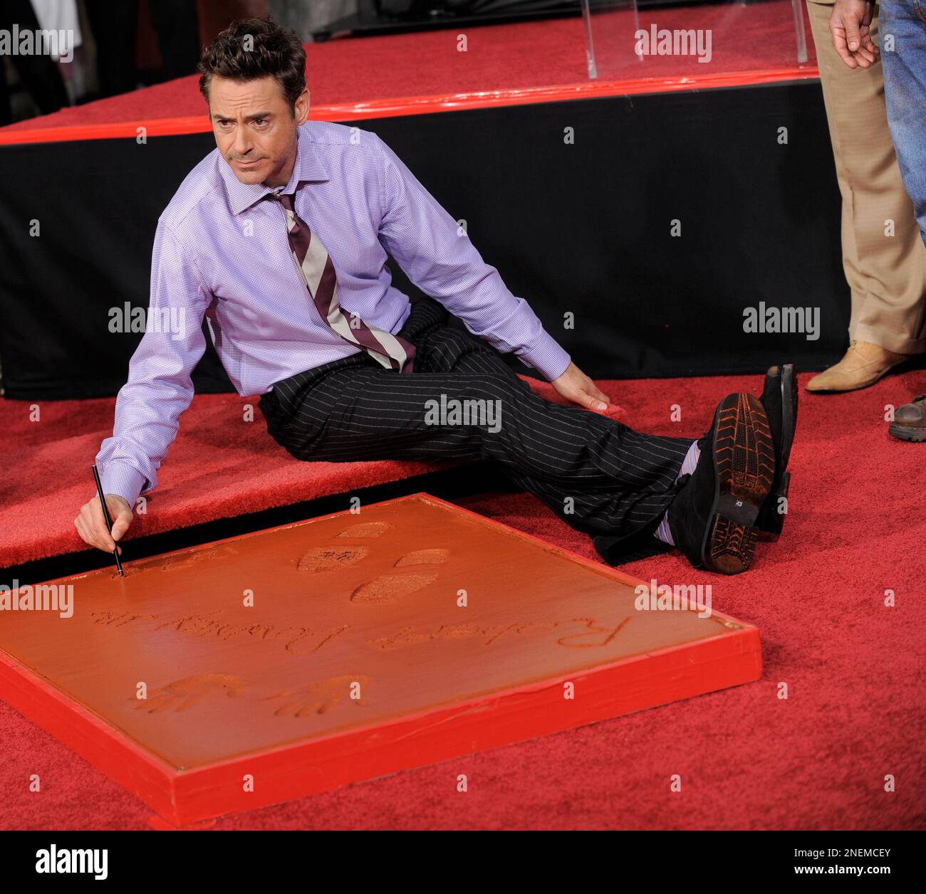 Actor Robert Downey Jr. writes his name in cement during a ceremony in ...