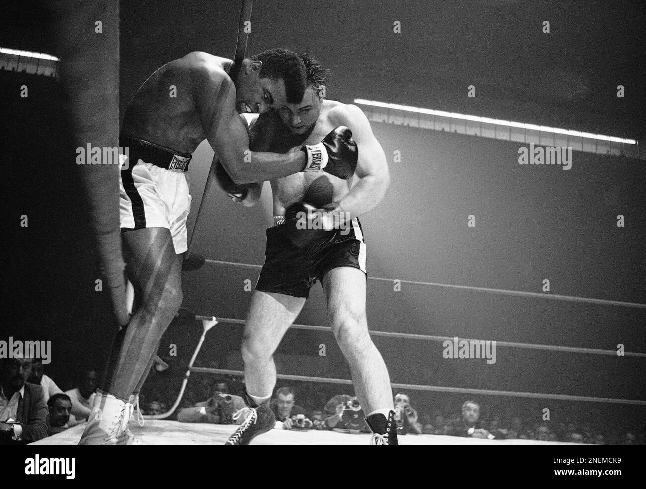 Champion Muhammad Ali is backed into the ropes as he takes a low right ...