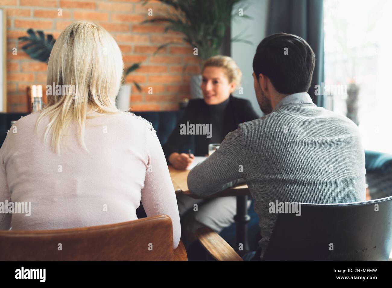 Back view of a couple furnishing their apartment on a meeting with ...