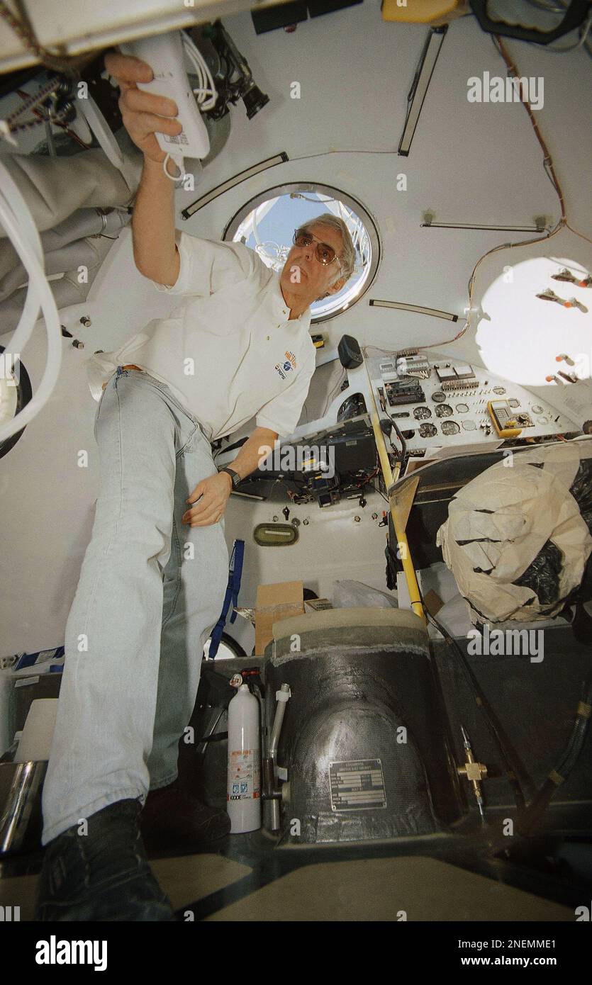 Flight pioneer Dick Rutan checks equipment inside the airtight, life ...