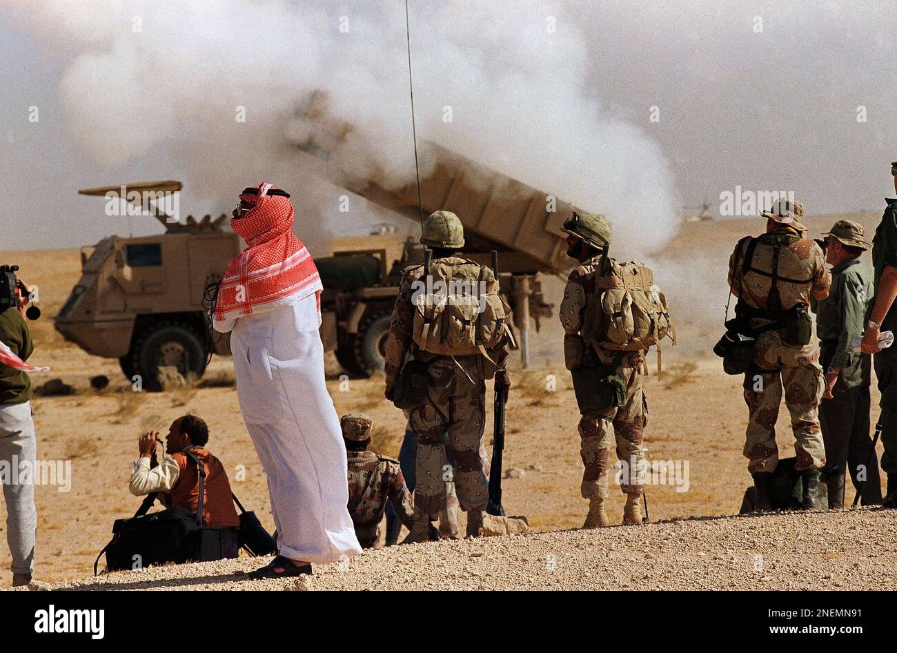 A Saudi Arabian official in traditional garb and Saudi soldiers watch a ...