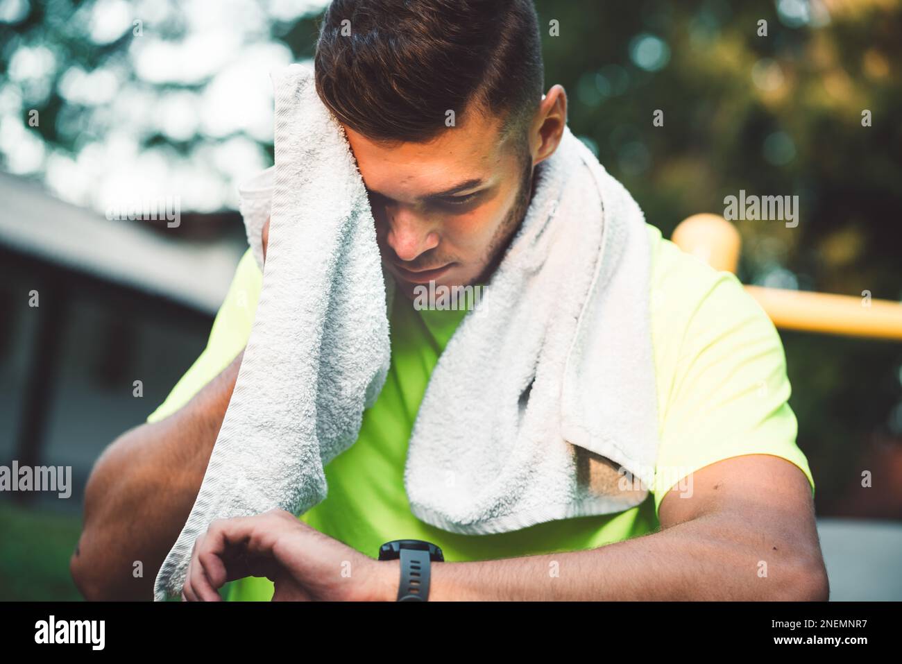 Sweaty fit man wiping him self with a towel after a workout while ...