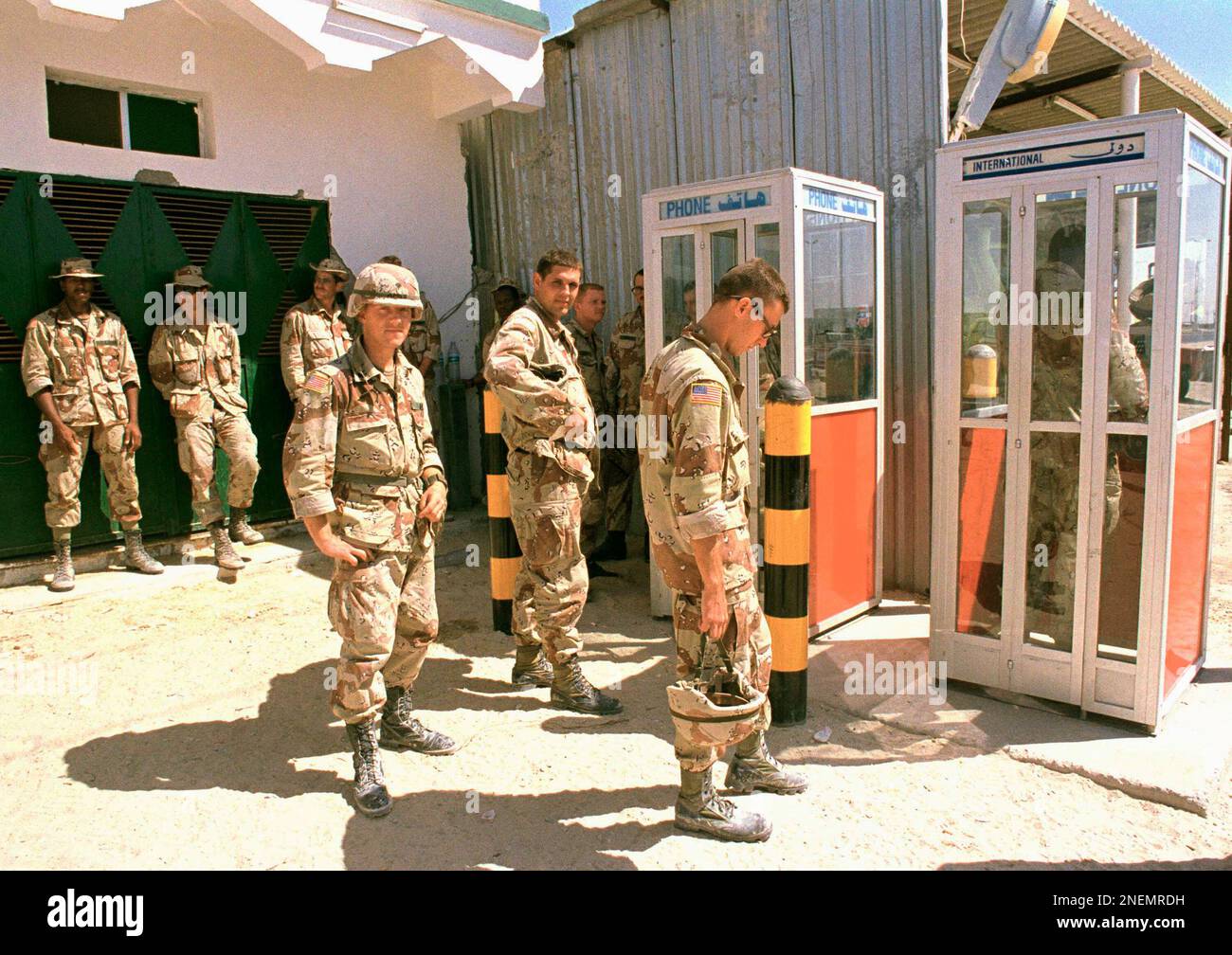 Troops from the 24th Infantry Brigade line up at phone booths in Saudi ...