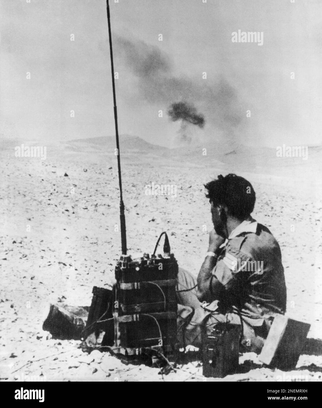An Israeli army sergeant with walkie-talkie watches a puff of smoke ...