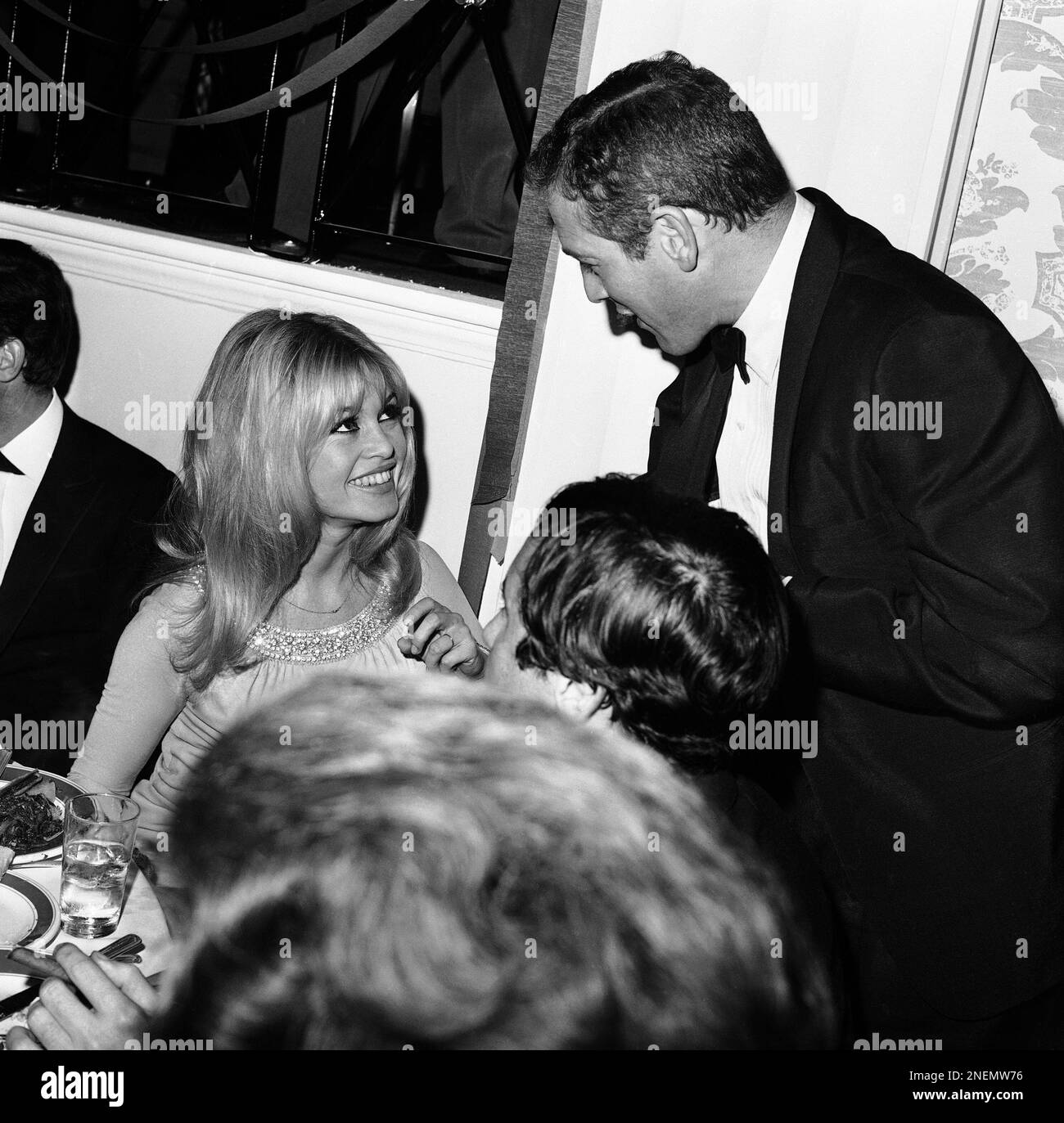Brigitte Bardot chats with actor Paul Newman at her table during ?Viva ...