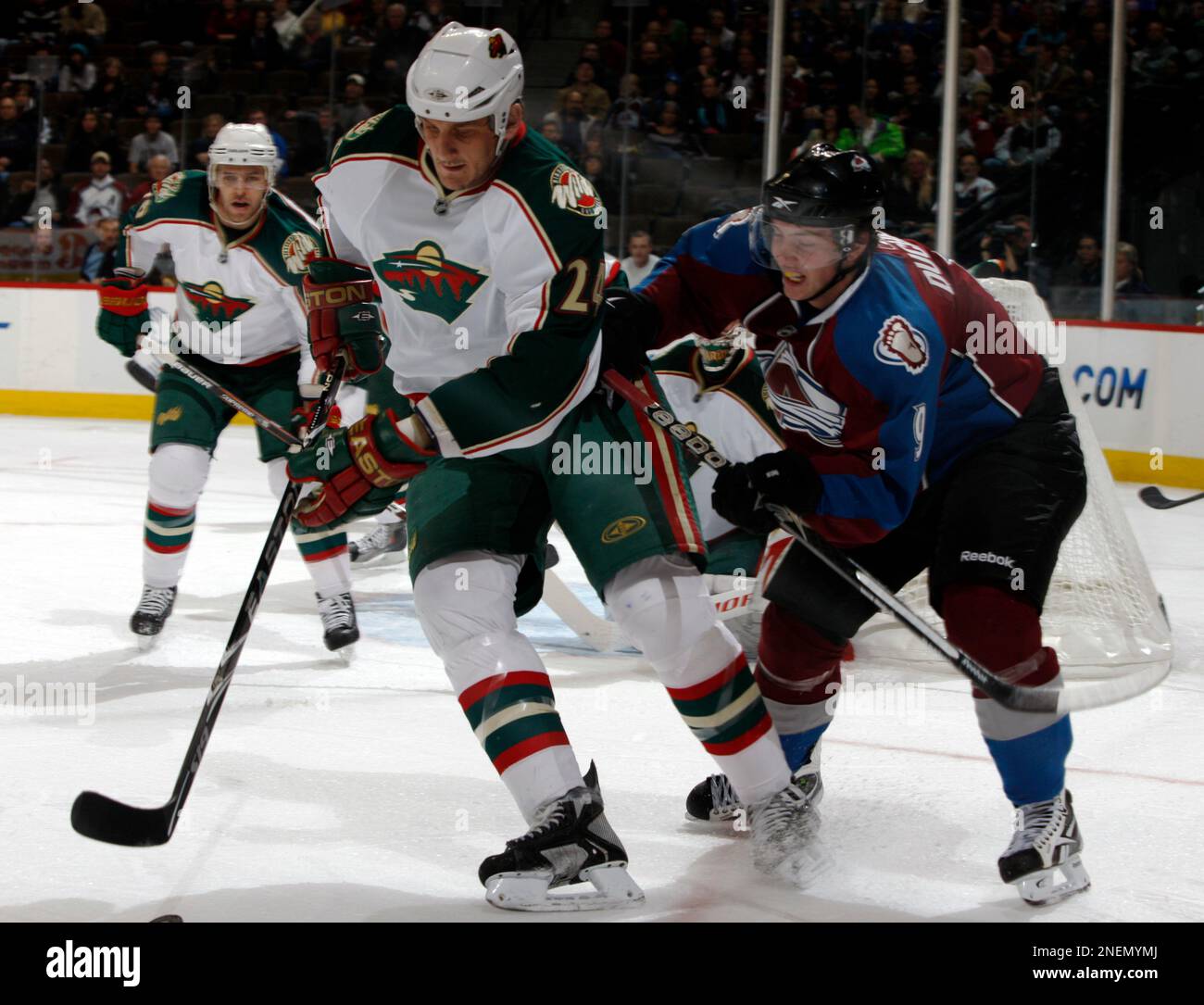 Minnesota Wild left winger Derek Boogaard, left, clears the puck as ...