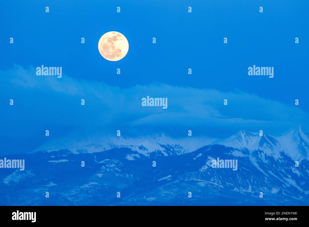 Full moon rising over the snow-capped La Sal Mountains at evening ...