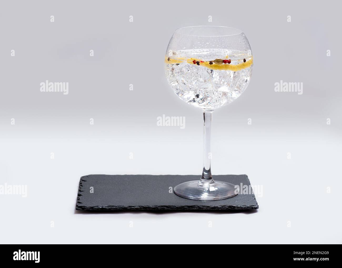 glass of gin and tonic on slate plate with white background Stock Photo ...