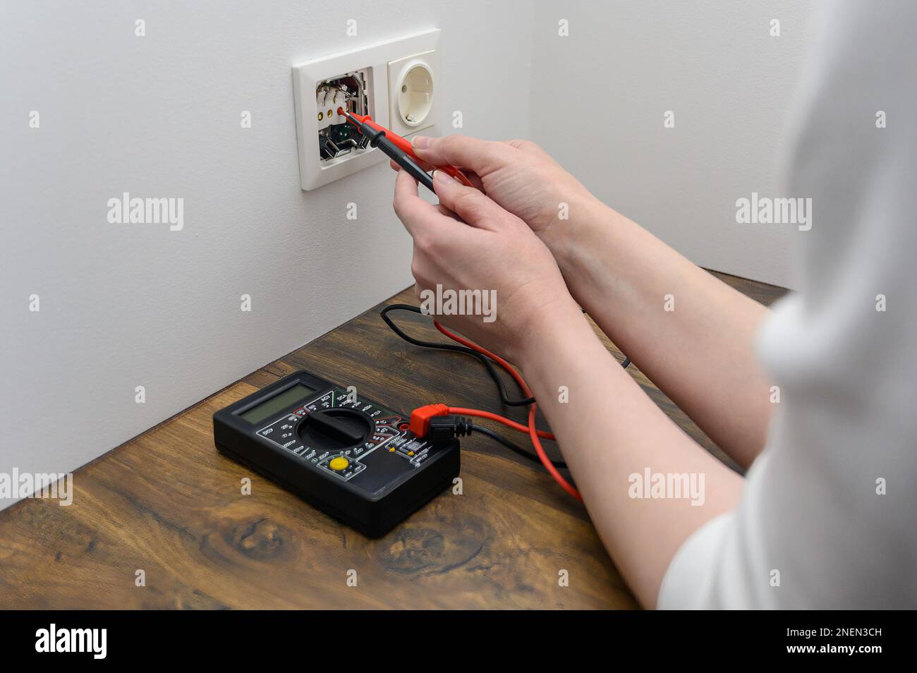 woman using digital multimeter to check current voltage in electric ...