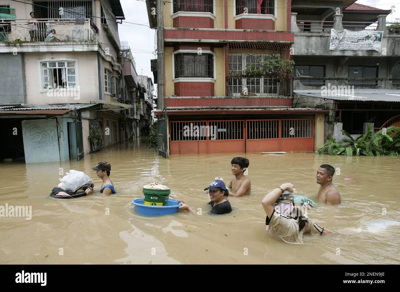 A family wades through chest-deep floodwaters in suburban Pasig, east ...