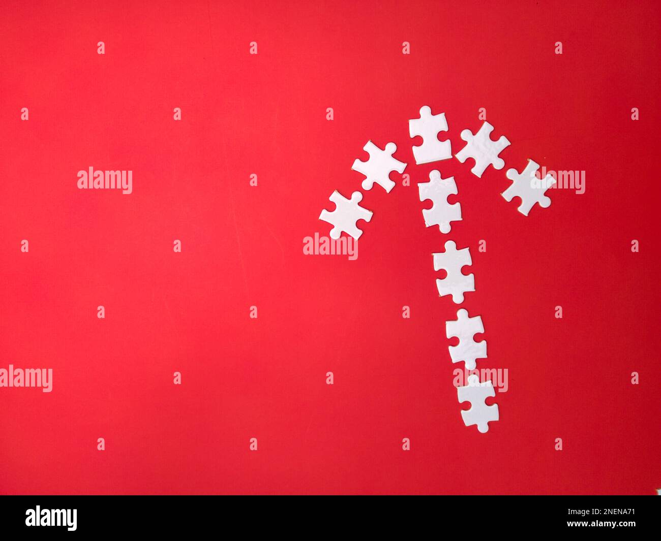 Some white puzzles arranged according to the shape of arrows on a red ...