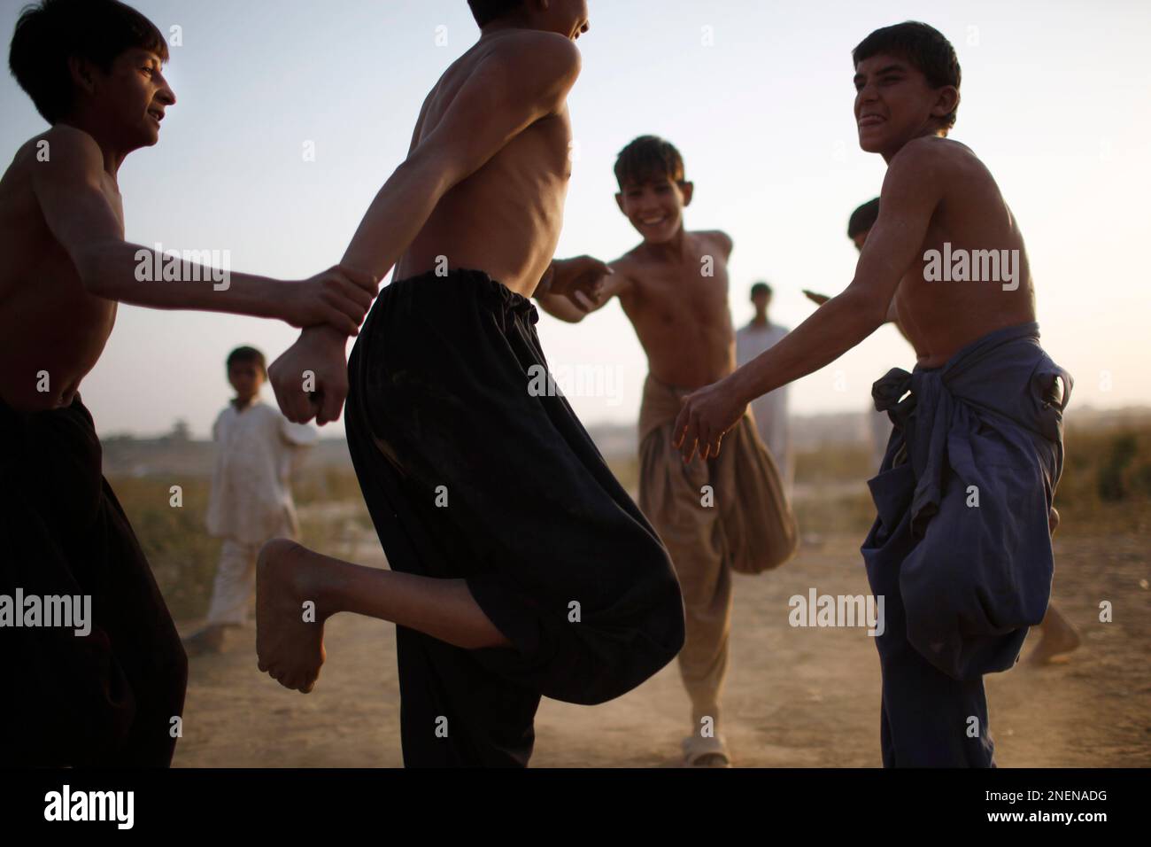 Children play a traditional game called Kabaddi, at an Afghan colony in ...