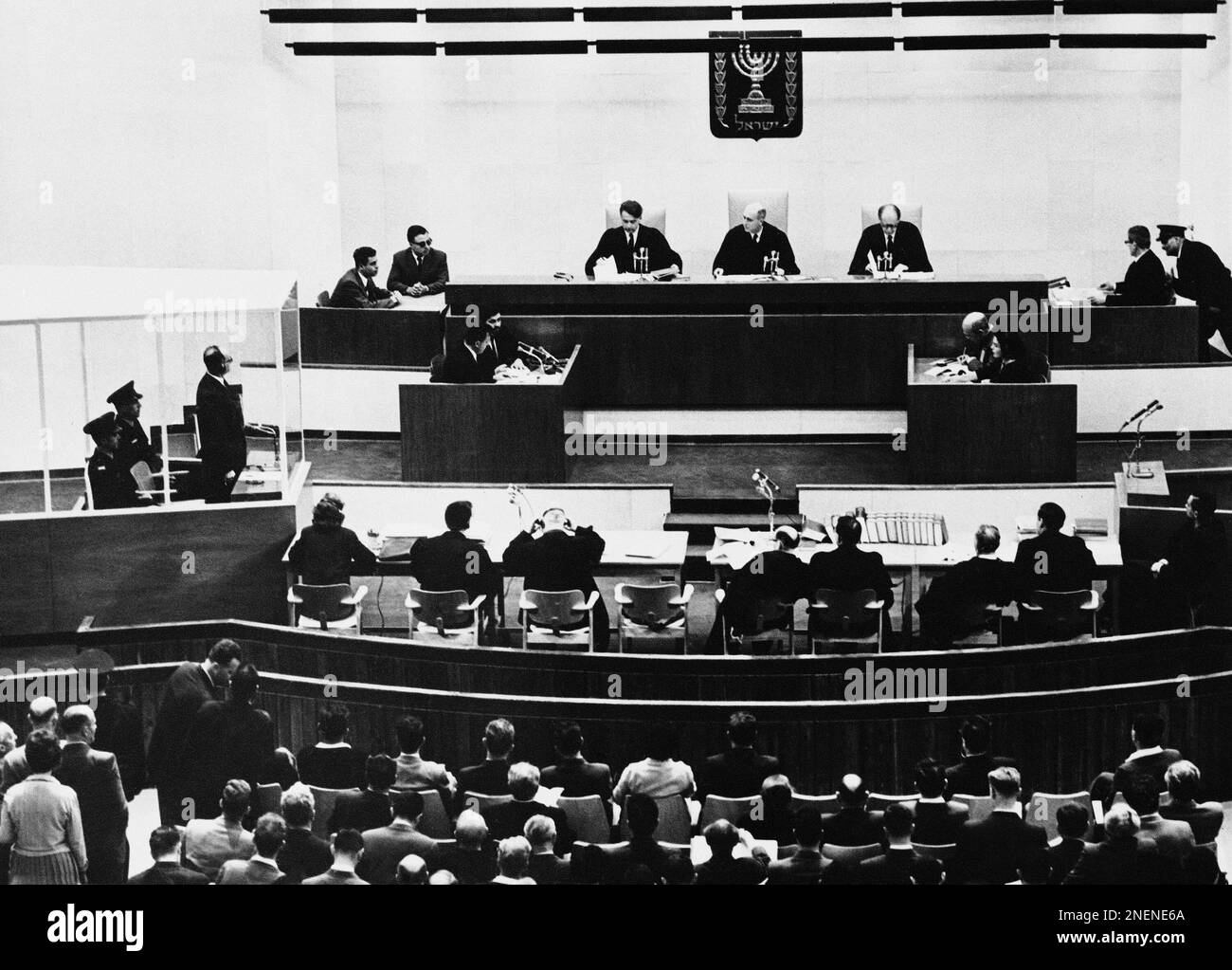Adolf Eichmann stands in bullet proof glass at left at opening of his ...