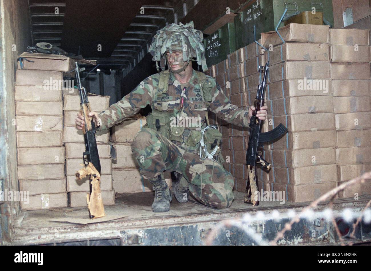 A U.S. Army ranger holds up two Ak-47s that were captured in an assault ...