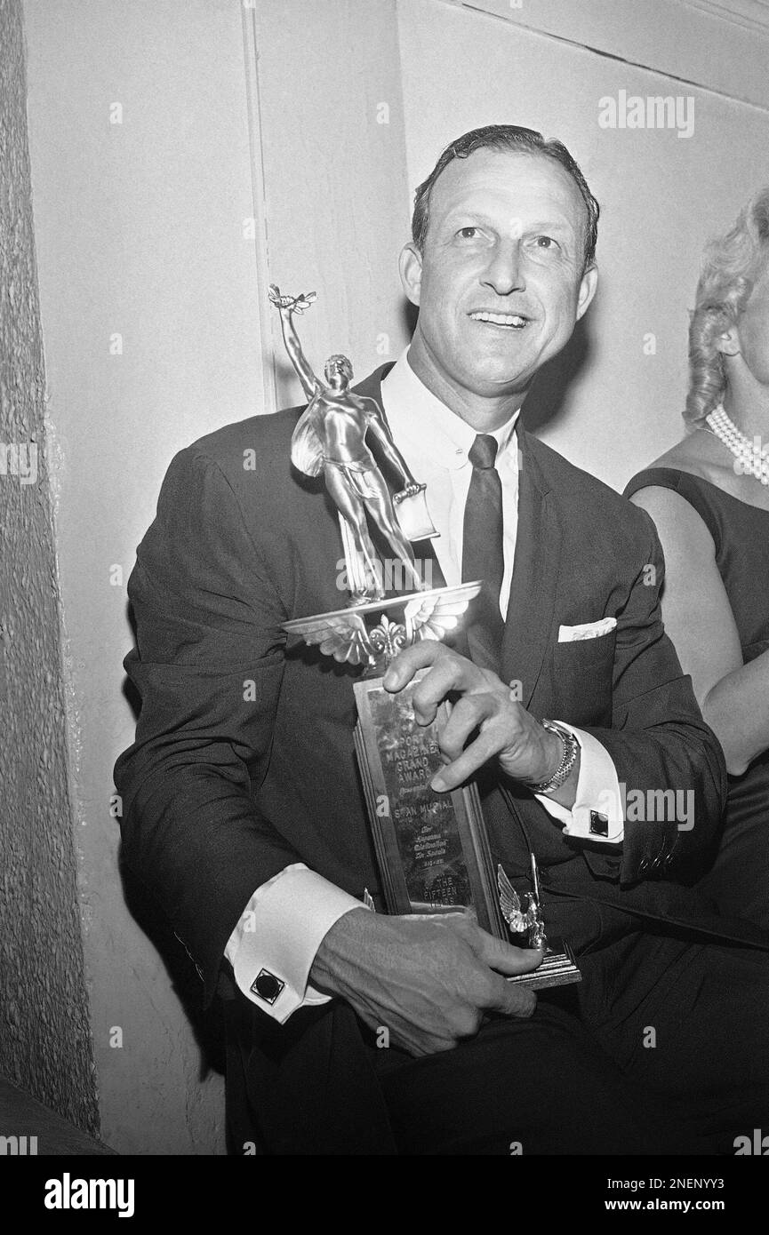 Stan Musial of the St. Louis Cardinals holds trophy presented to him by ...