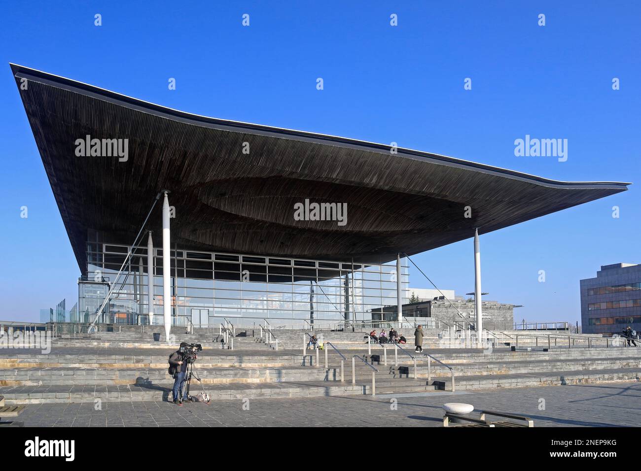 Filming a piece-to-camera outside the Senedd building, Cardiff Bay ...