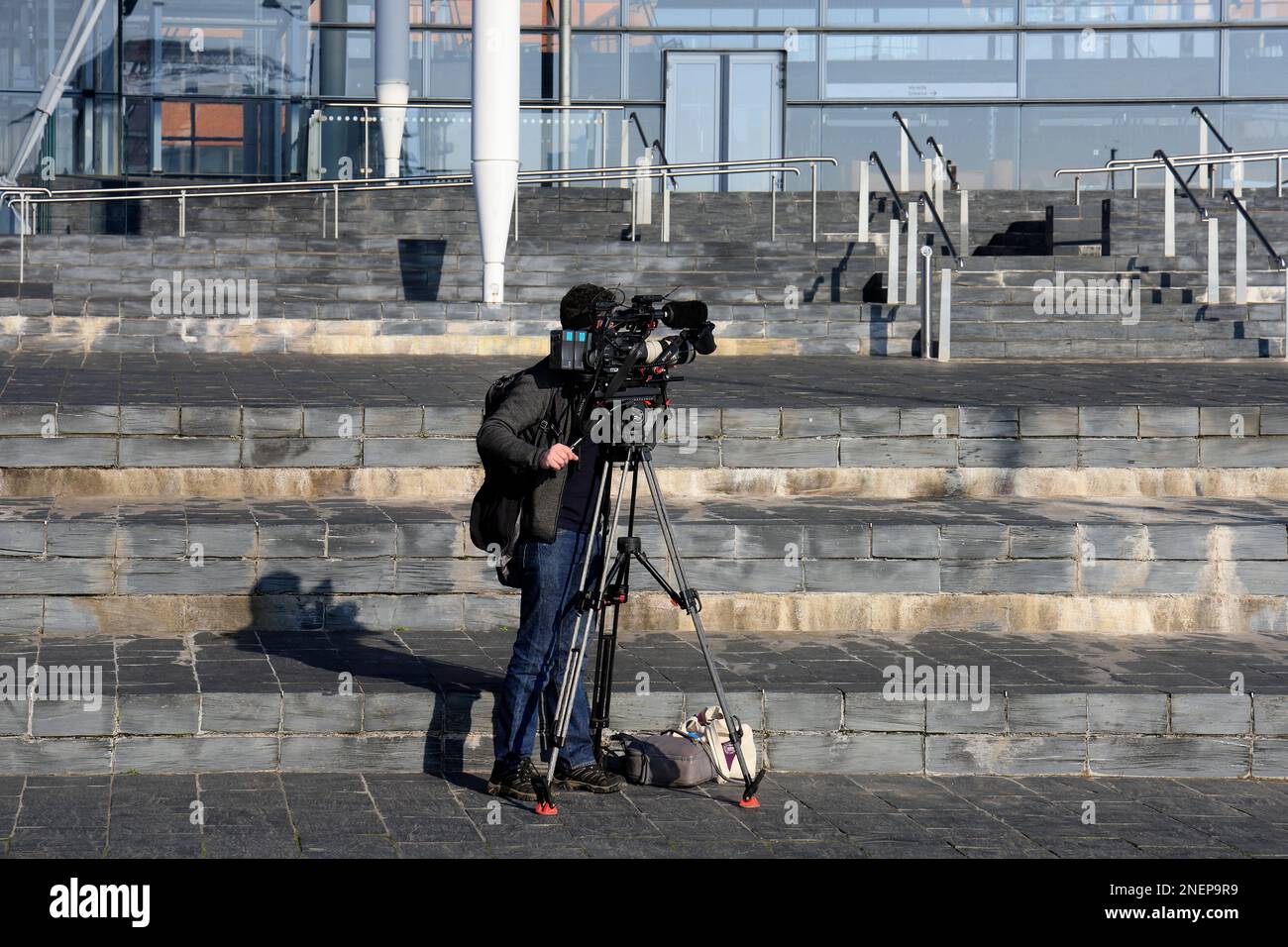 Filming a piece-to-camera outside the Senedd building, Cardiff Bay ...