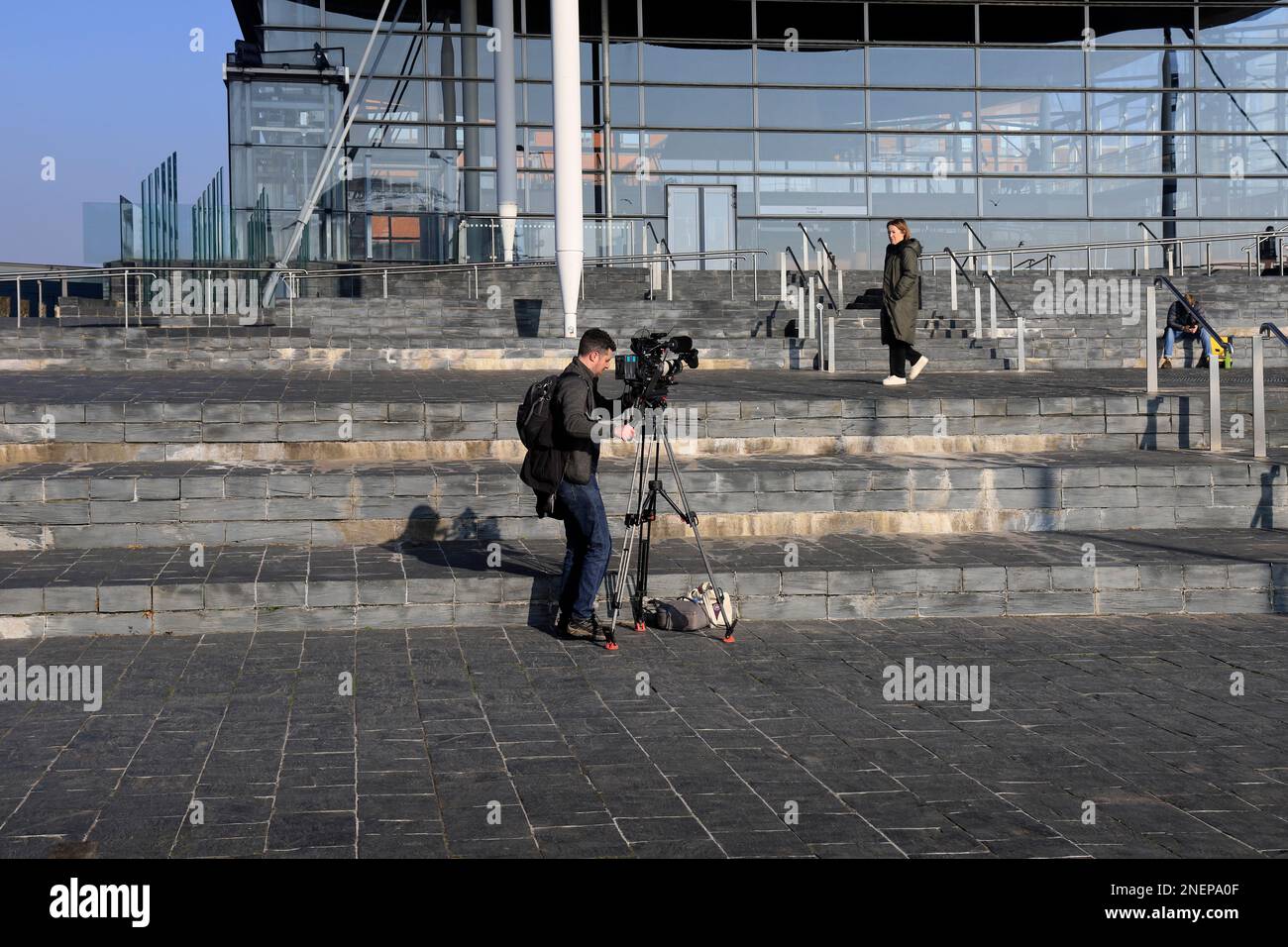 Filming a piece-to-camera outside the Senedd building, Cardiff Bay ...